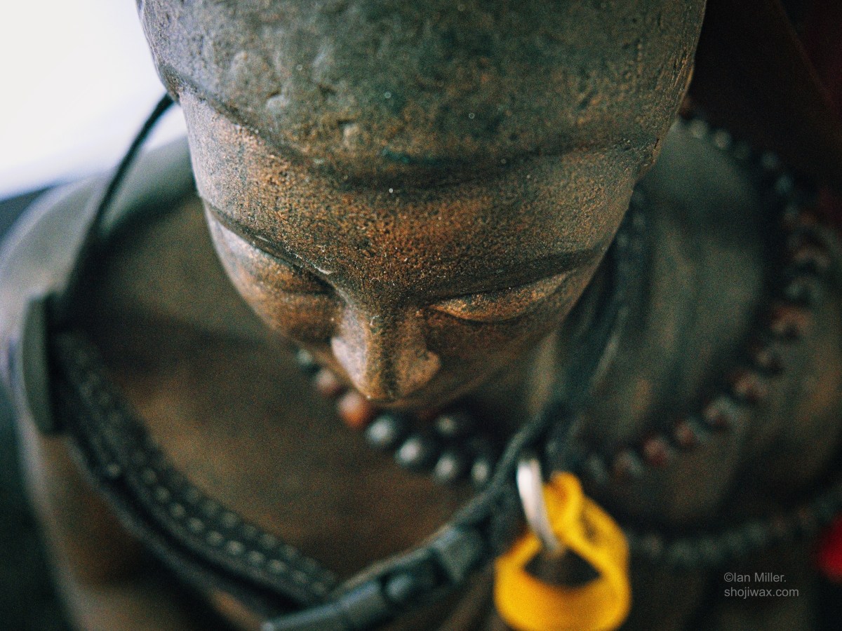 Plaster buddha, wooden beads and a dog collar. – shojiwax.com